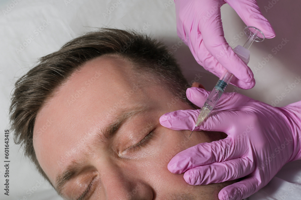 Handsome man gets beauty facial injections. Photo of an Attractive man ...
