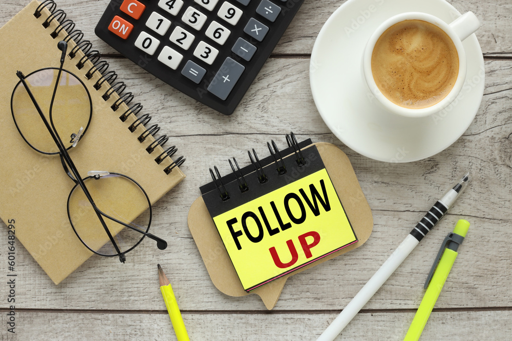 Top view of open laptop with text Follow Up .sticky note, coffee cup ...