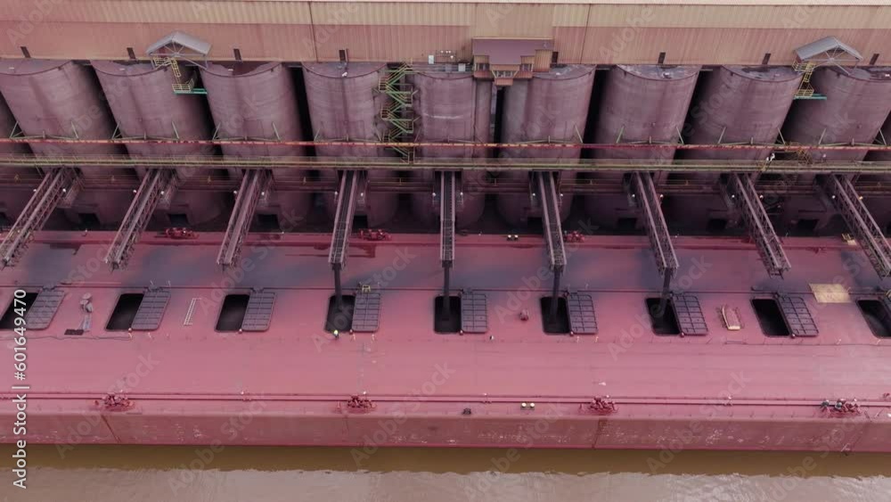 Conveyor belts loading iron taconite into haul of large freight ship at ...