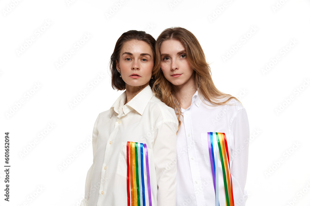 Portrait of two young women wearing white shirt with rainbow line ...