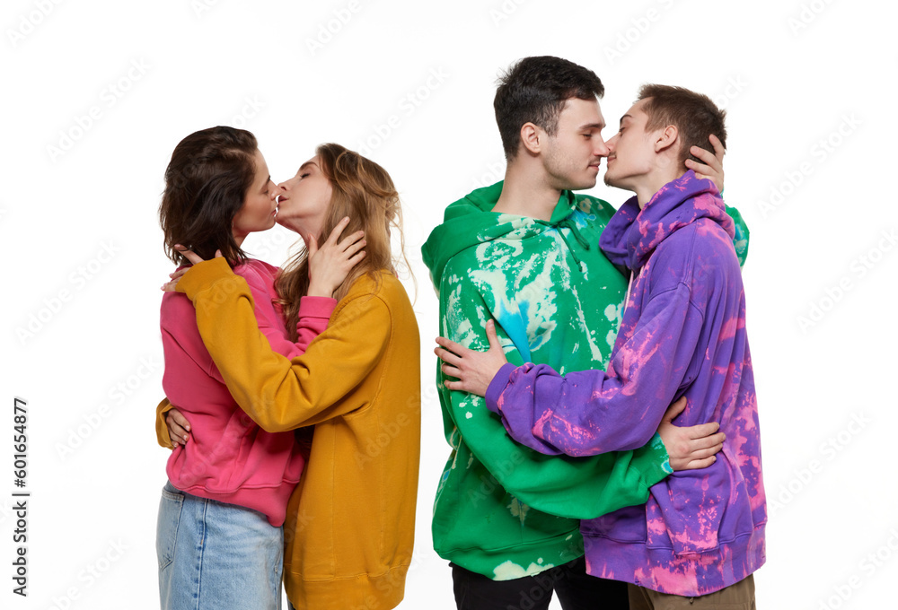 Portrait of four young people, same sex couples in colorful hoodies ...