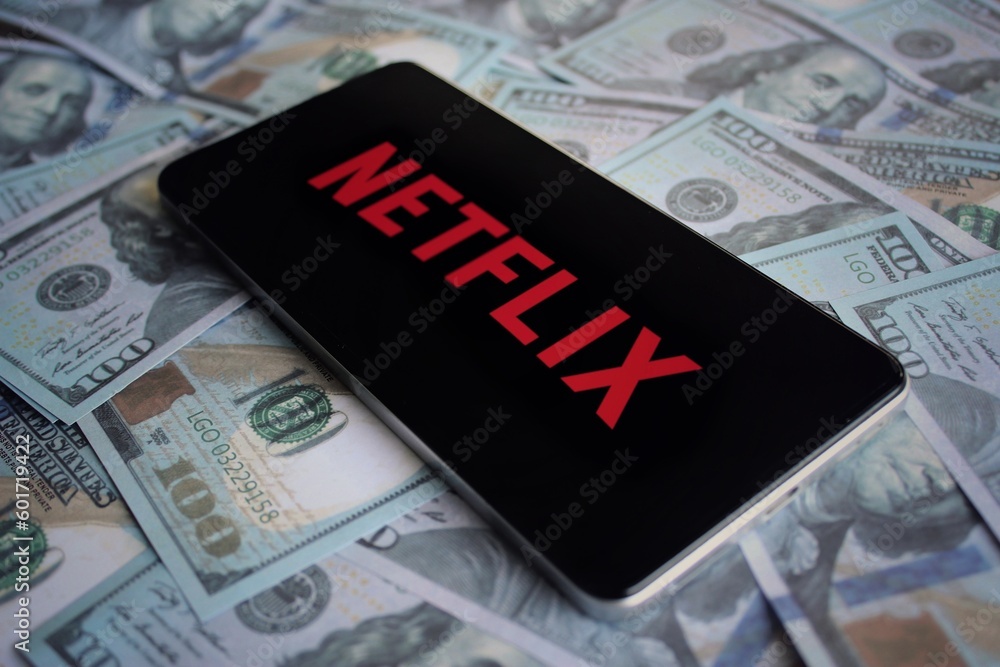 Netflix logo displayed on smartphone on top of pile of money. Stock ...