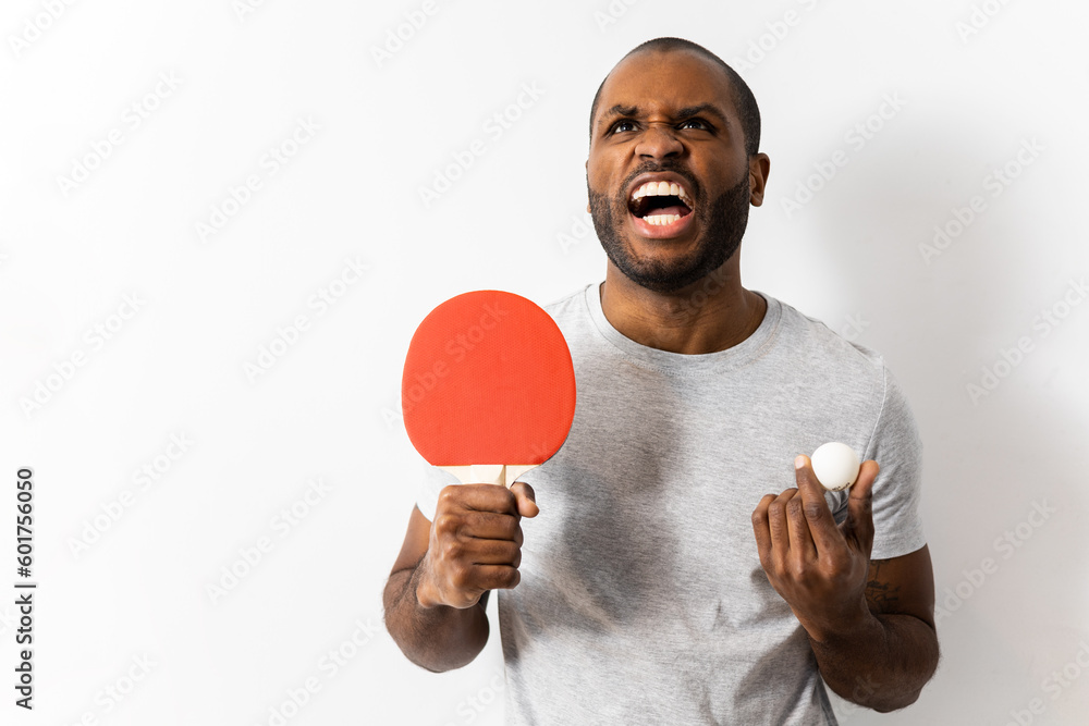 Dark-skinned adult man poses with a ping-pong racket and a ball. The ...