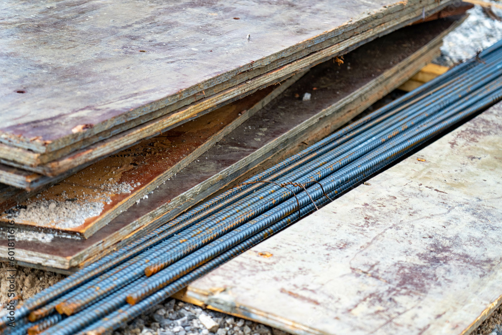 Rebar and construction materials stacked haphazardly on a wet ...