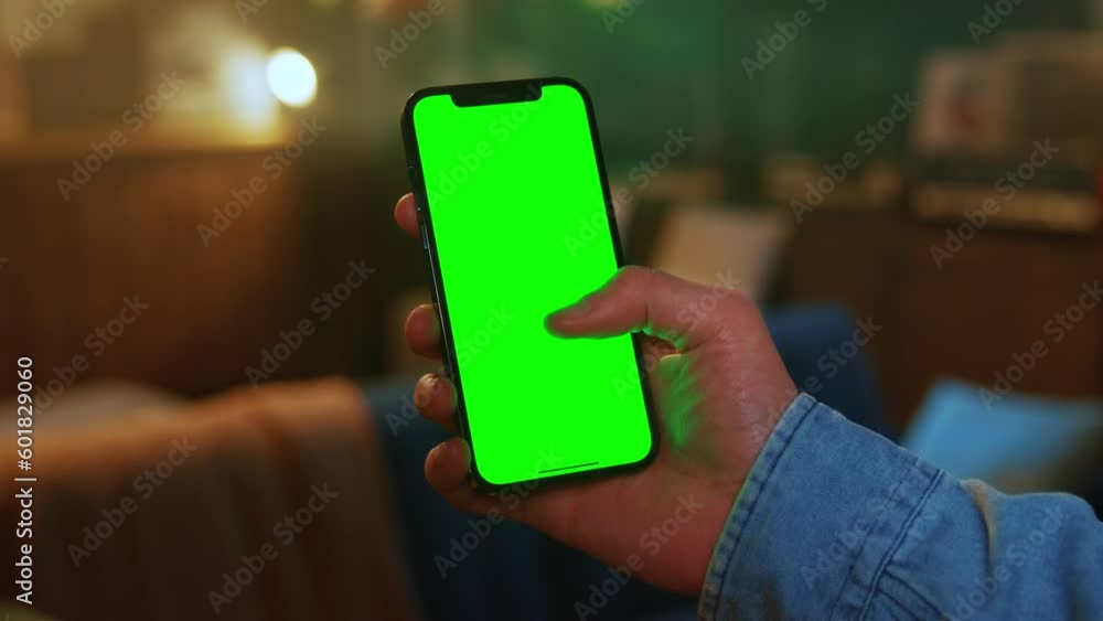 Hands holding using a mobile phone with a vertical green screen. Social media. Smartphone. Mock ...