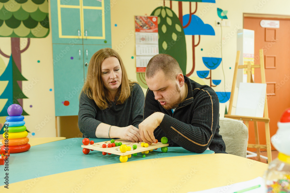a psychologist is engaged with an autistic man with mental disabilities ...