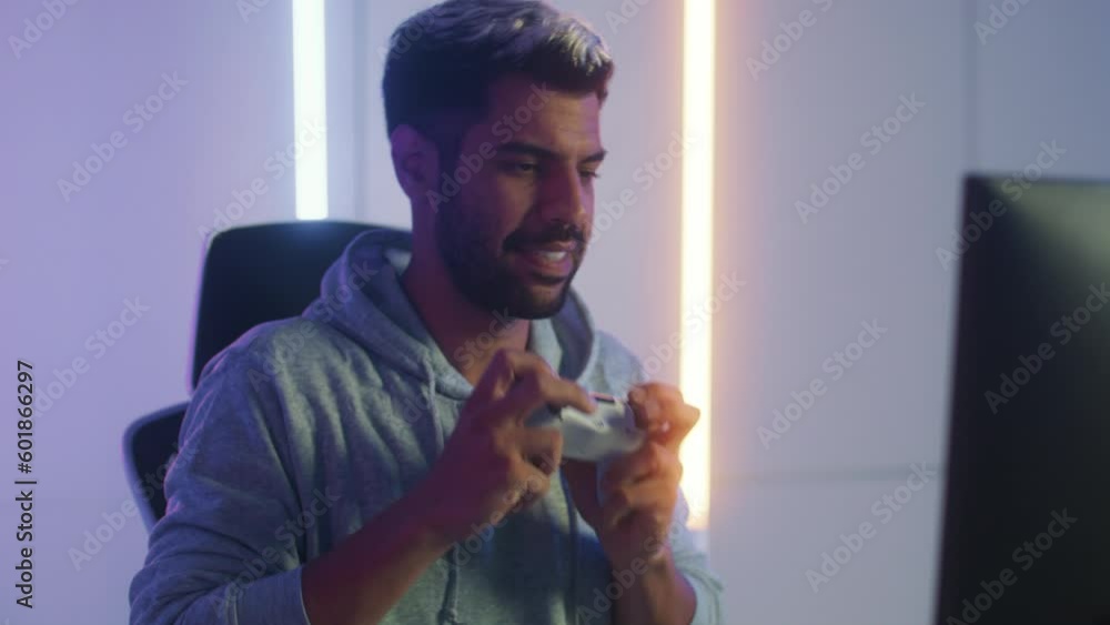 Excited Young Middle East Asian man using joystick wireless controller ...