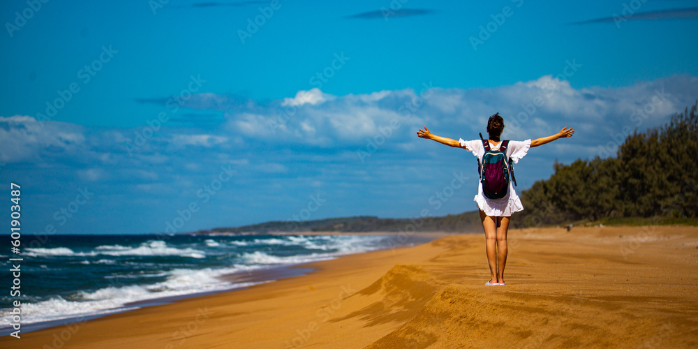 happy girl in white dress enjoying freedom on the beach; backpacker ...