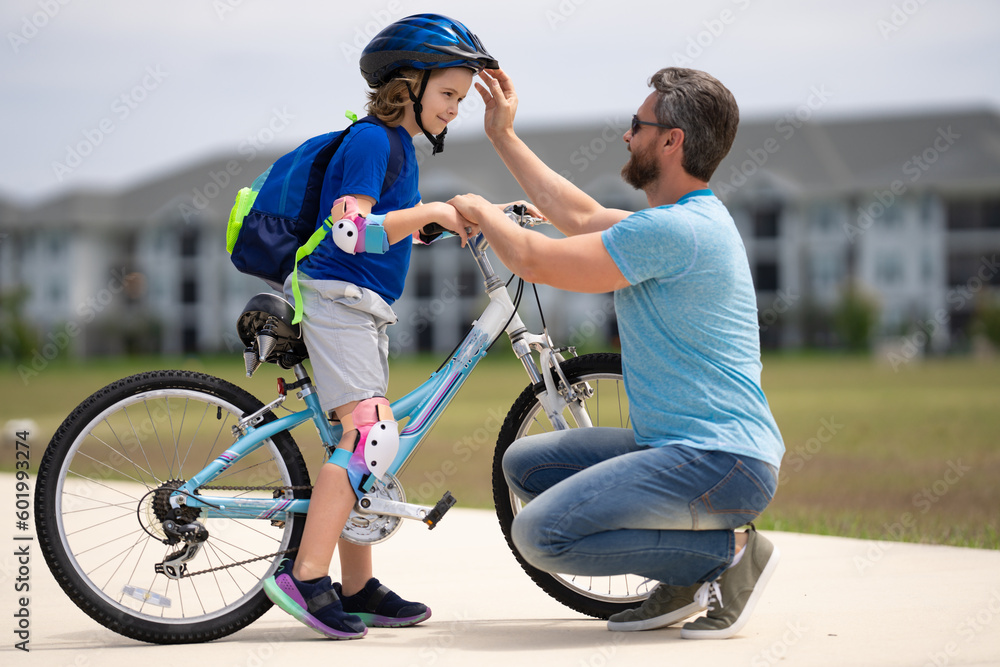 Fathers day and summer family weekend. Father helping his son to wear a ...