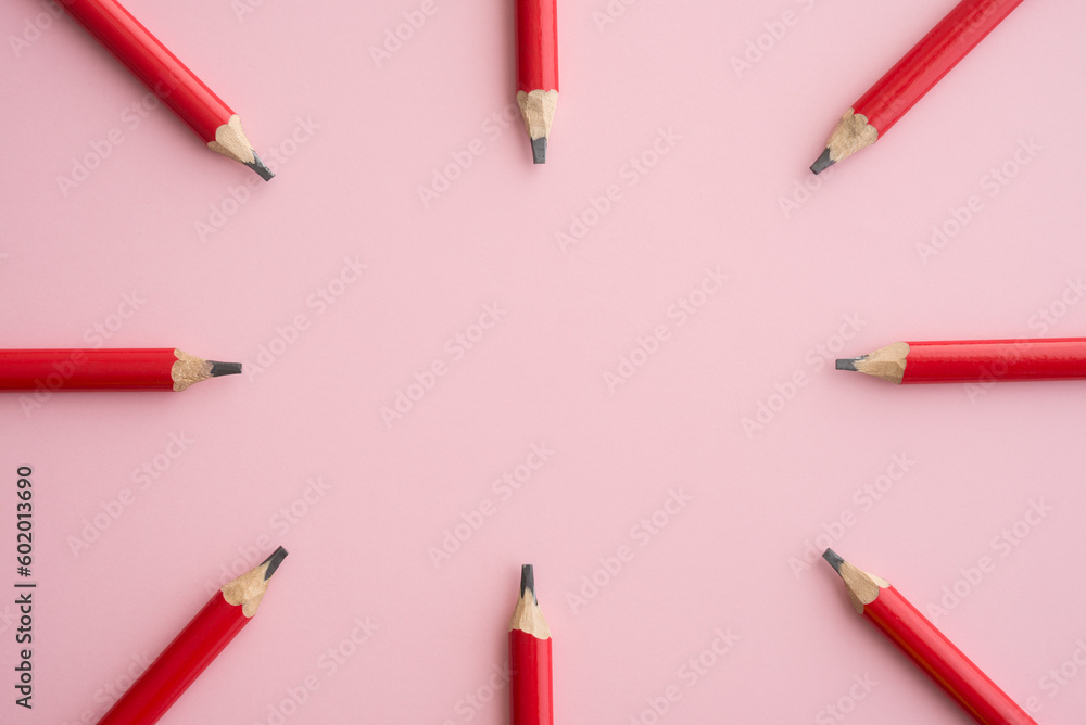 Flat lay of red pencils around border frame on pink paper background ...