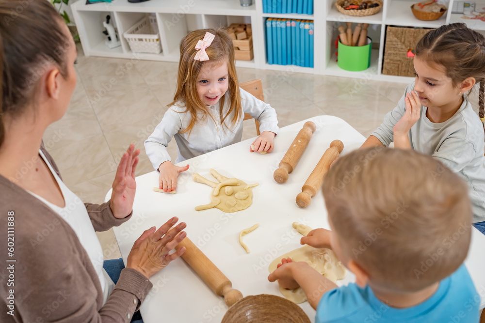 Happy cheerful children playing with a play dough in a kindergarten ...