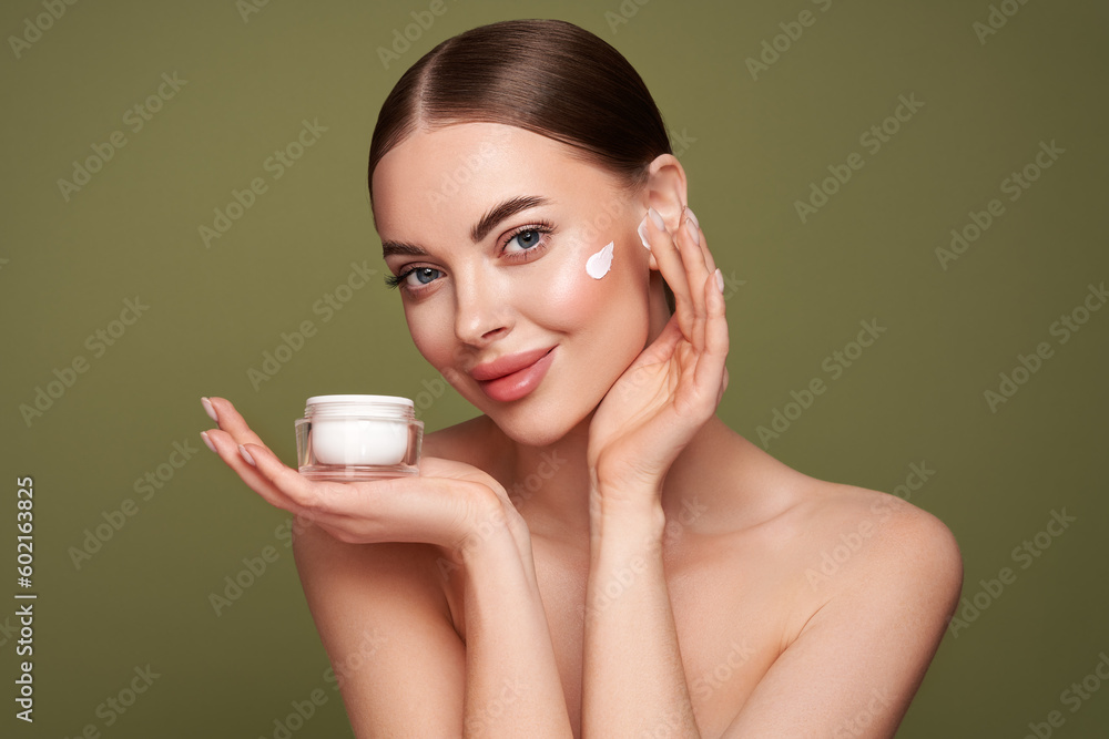 Beauty woman applying cream on her face. Young woman with clean fresh ...