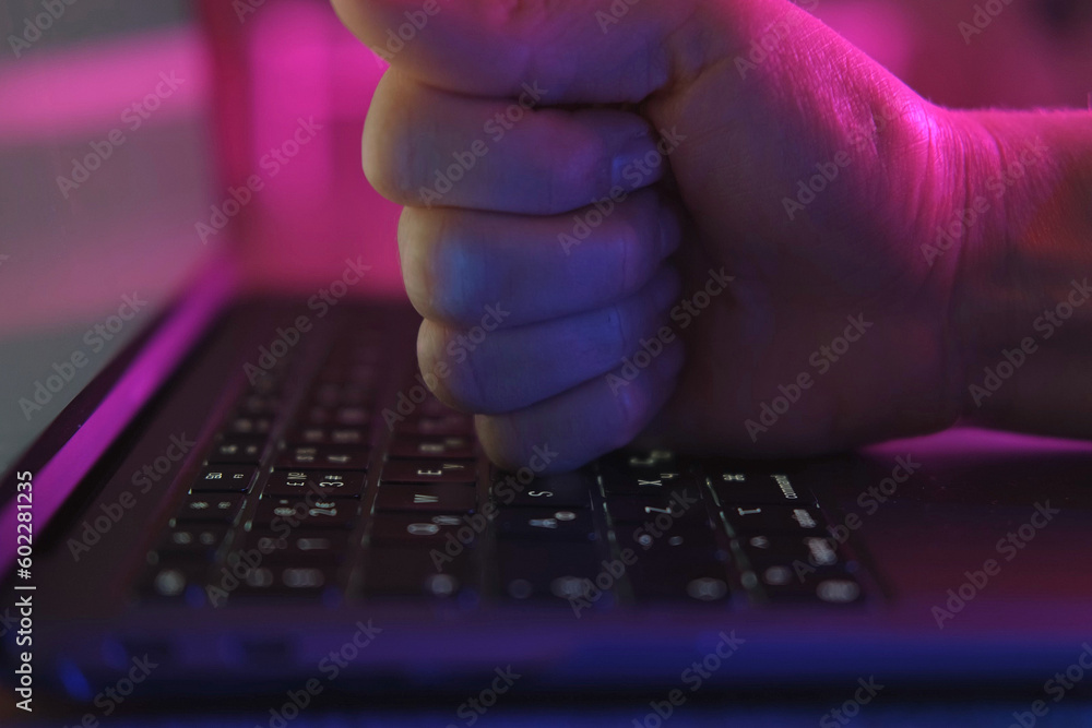Foto de Human fist bump on the keyboard of laptop. Neon pink blue light ...