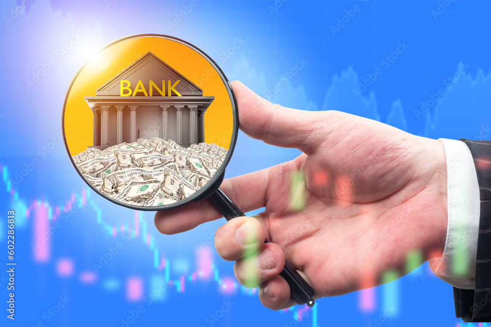 Foto de Bank building under magnifying glass. Financial chart is ...
