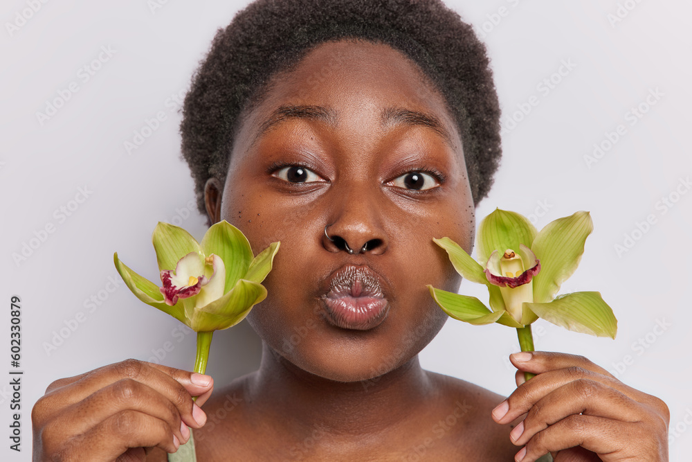 Headshot of naturally beautiful dark skinned young woman keeps lips ...