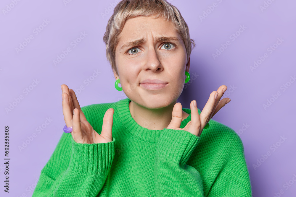 Displeased confused blonde woman spreads palms has doubtful unhappy ...