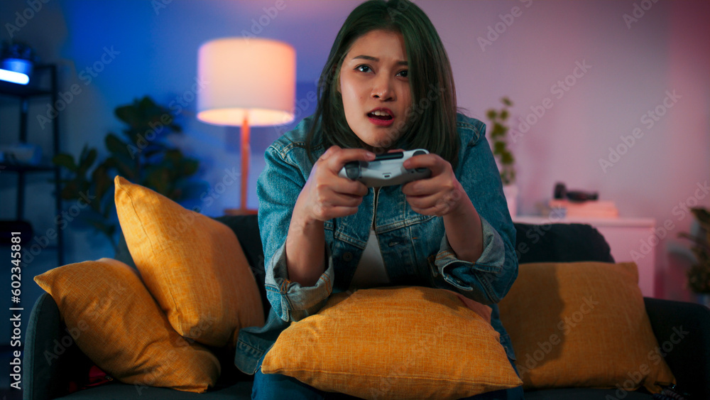 Excited beautiful Asian woman using joystick wireless controller enjoy ...