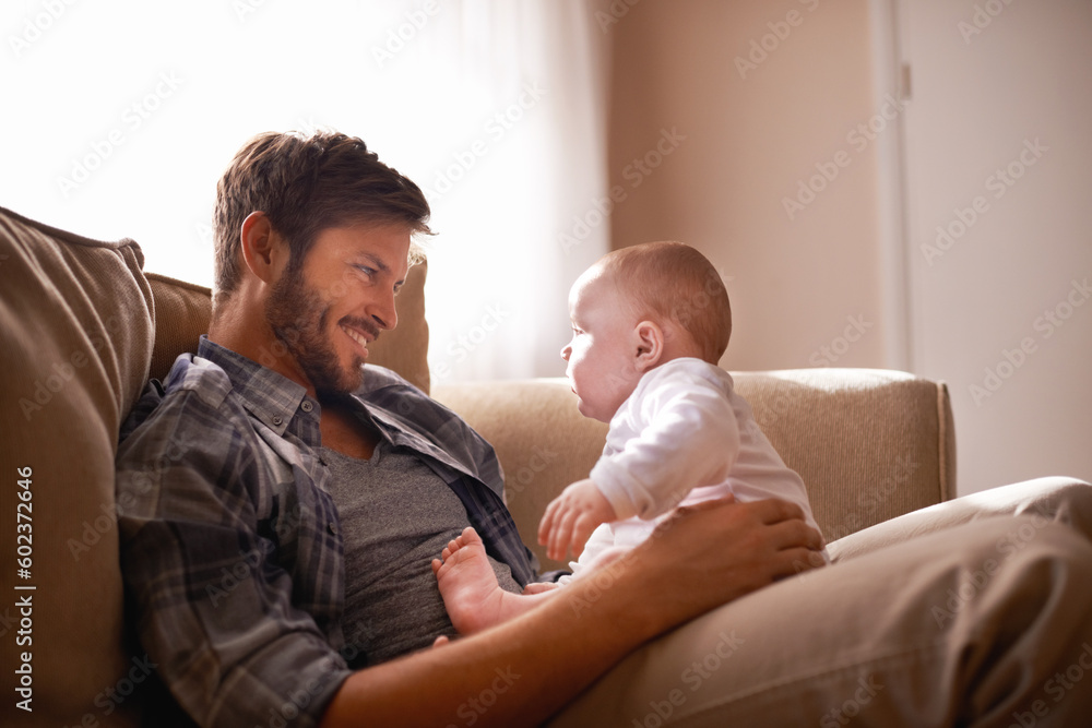 Smile, father and baby sitting on lap on sofa in home living room ...