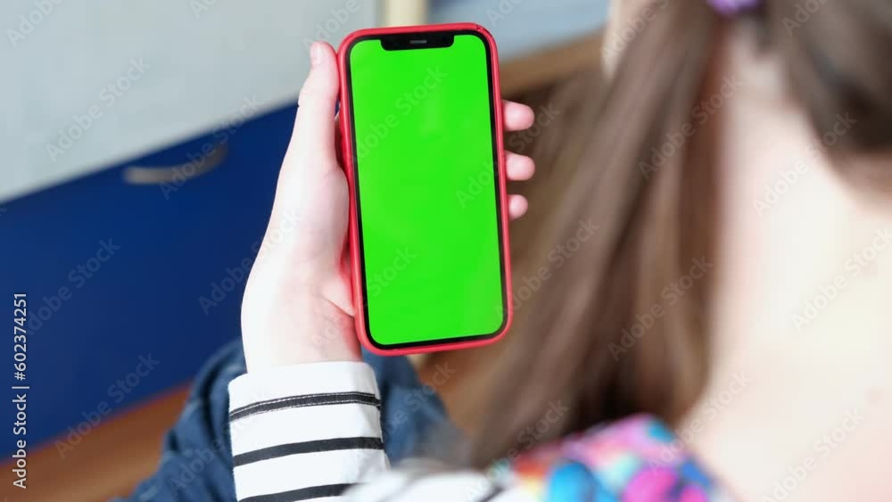 Teenage girl of 12 years with backpack holds a mobile phone green ...