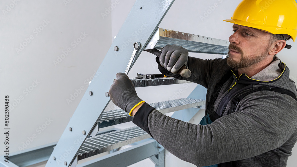 Foto de Installation of a steel staircase. The fitter fastens the ...
