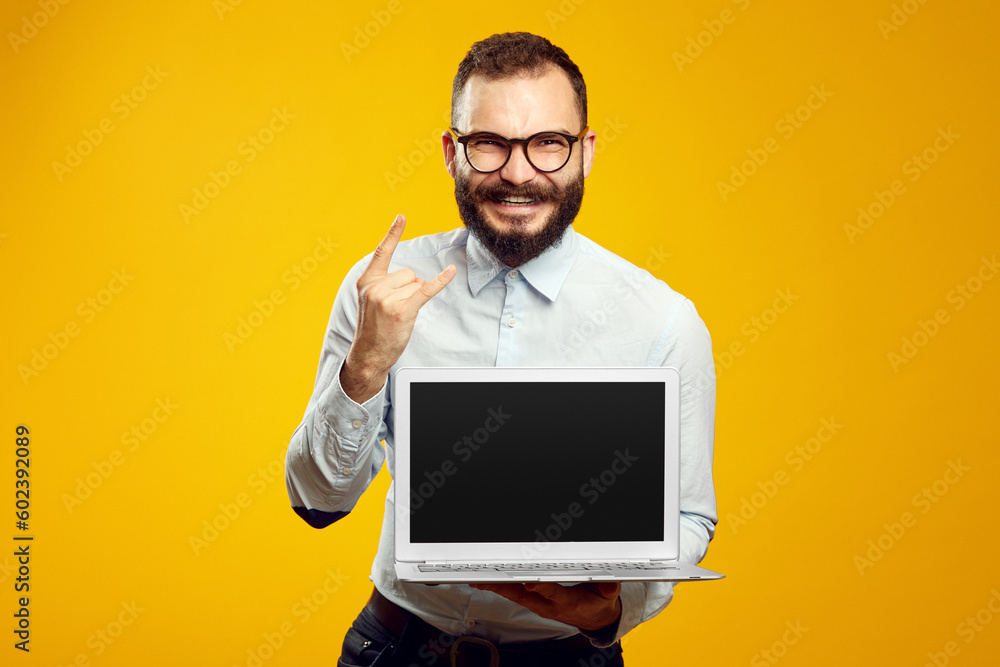 Excited Handsome Male Wearing Glasses Showing Laptop Screen And Rock