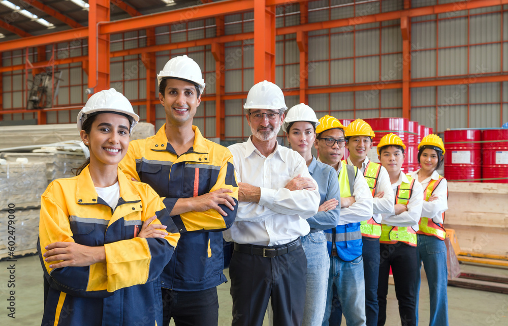 Group of male and female factory labor stand smiling together with arms ...