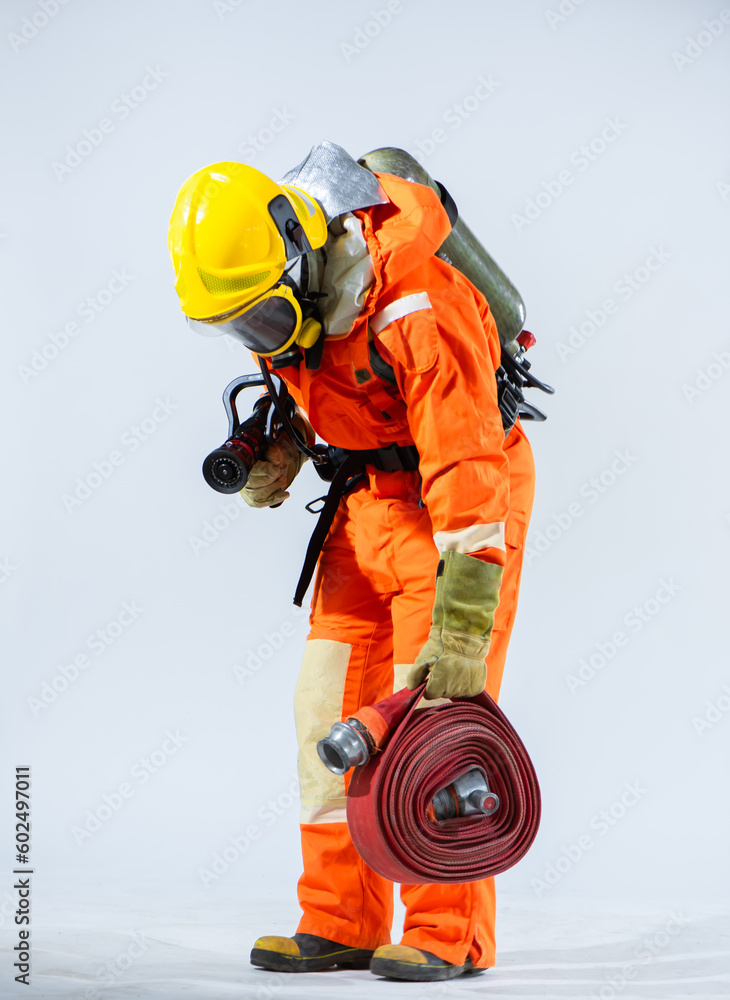 Against the clean and neutral backdrop the firefighter holding the fire ...