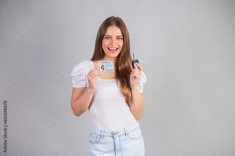 Blonde Brazilian woman holding motor vehicle driver's license and car ...