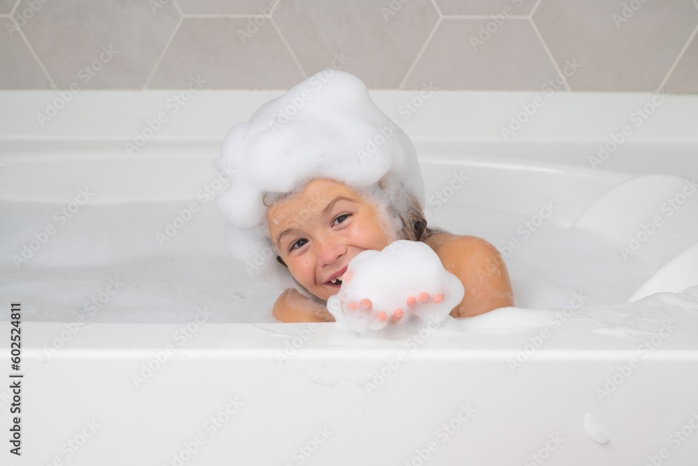 Kids face in foam. Cute child washing and bathing in a bath with foam ...
