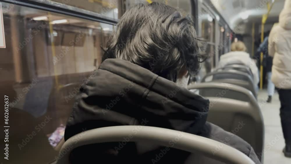metro underground. teen girl a sitting in the subway with people back ...