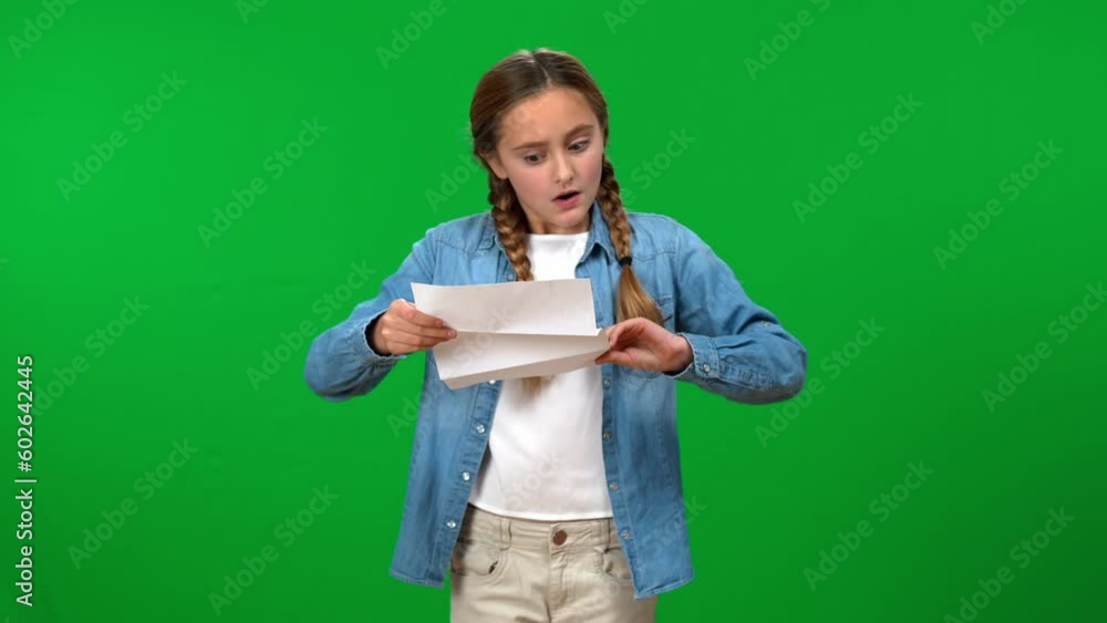 Teenage Caucasian girl unfolding letter tearing paper with dissatisfied ...
