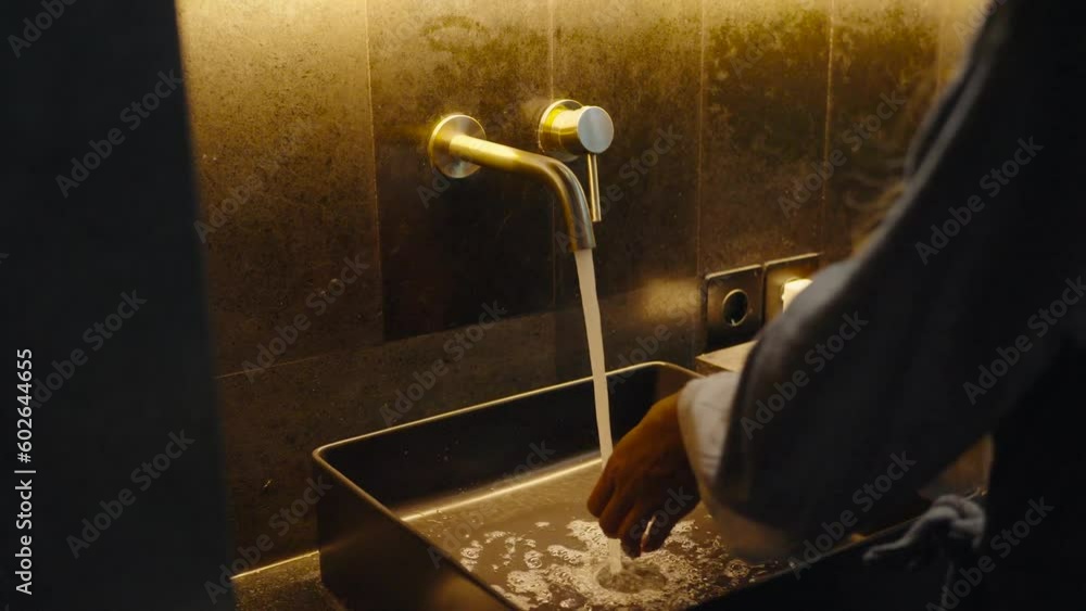 Unrecognizable woman washing hands and face at home in the morning ...