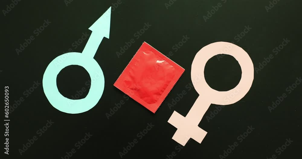 Hand of woman putting condom in red package between male and female ...