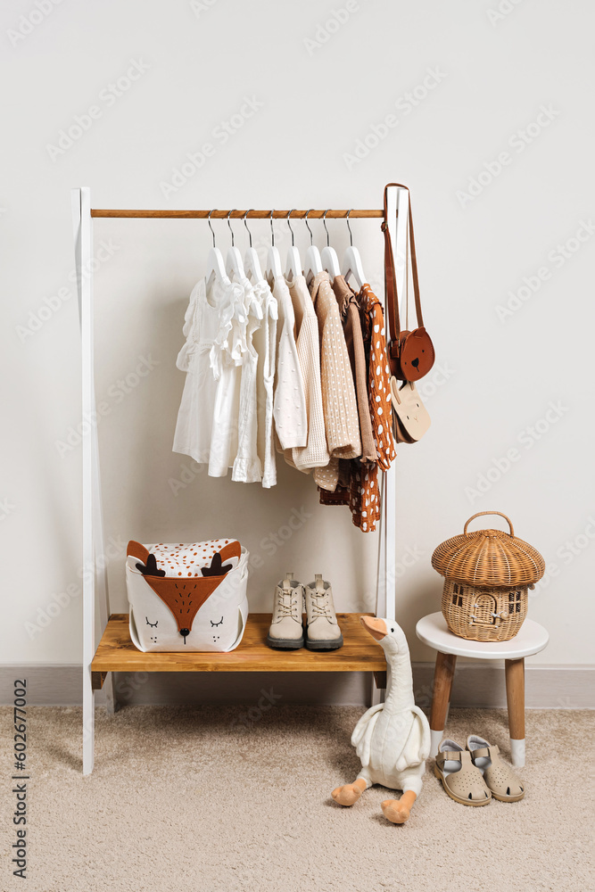 Clothing Rack with kids outfits and storage baskets in children's room ...