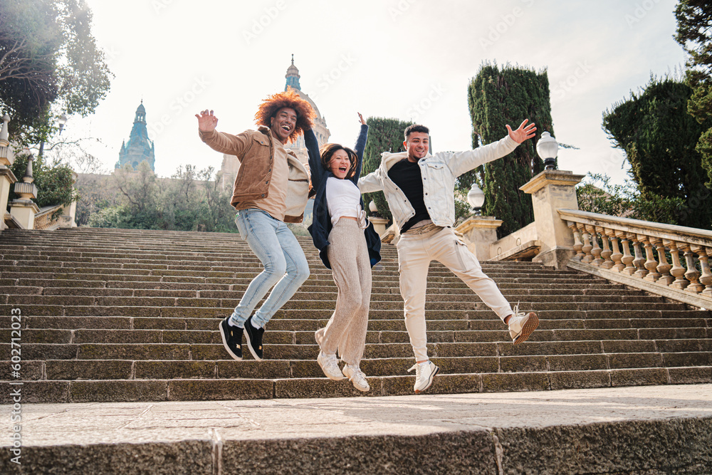 Group of multiracial happy friends having fun jumping on the street ...