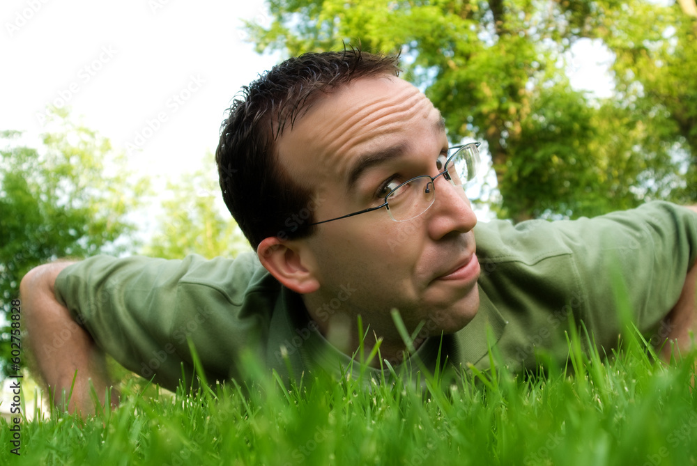 Seen from a bugs eye view, a young man creeping along the ground to ...