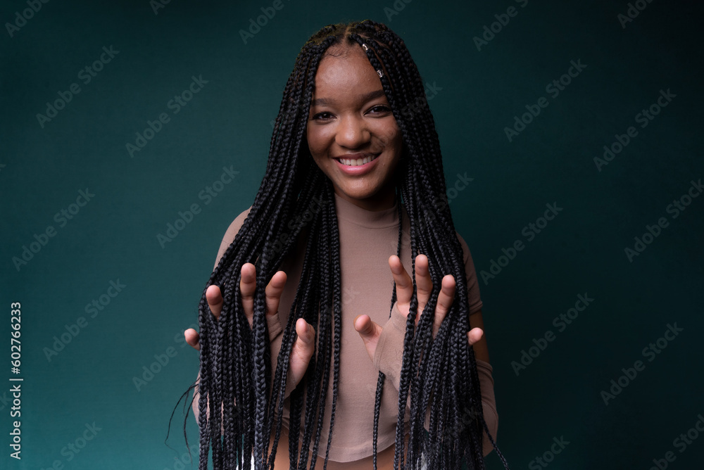 Young pretty black woman showing her hands through her braided hair. Stock Photo | Adobe Stock