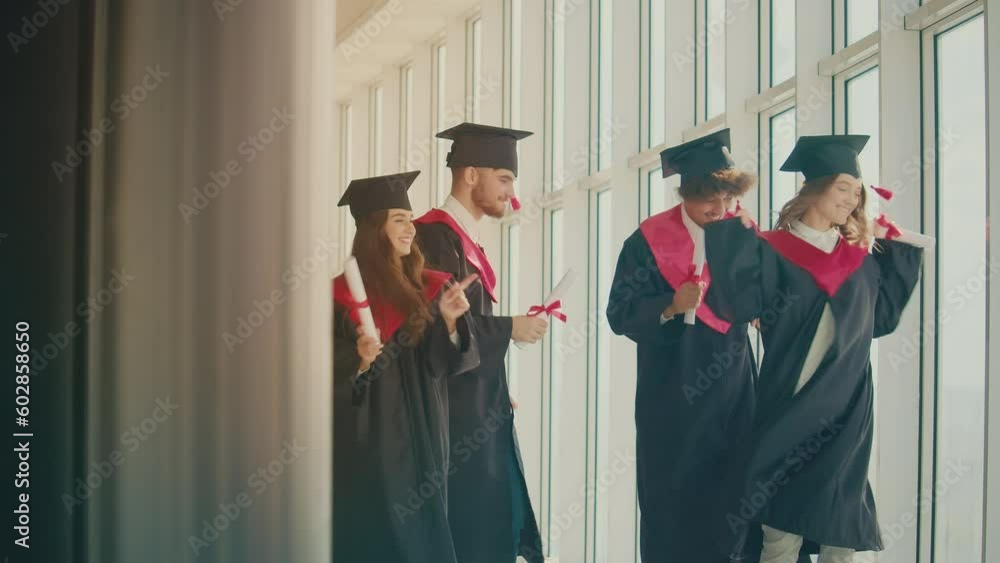Positive Group of Successful Graduates Dancing With Diplomas in Hallway ...