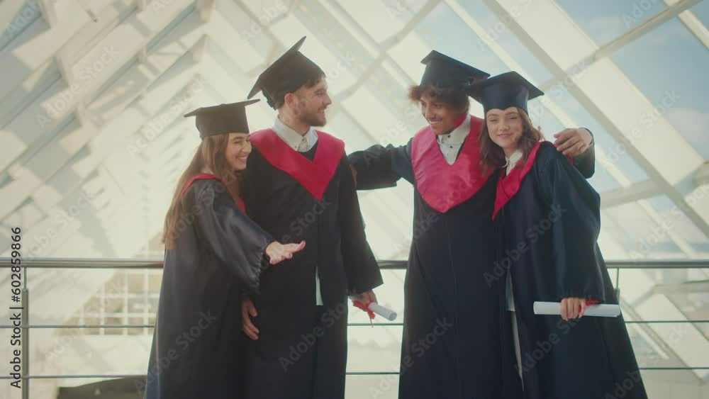 Portrait of Positive Group of four Graduates With Diplomas Hugging ...