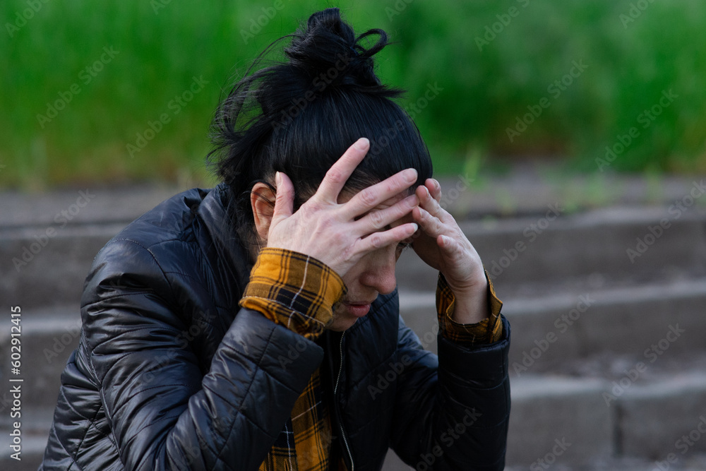 sad homeless woman drug addict sitting on the steps in the park ...