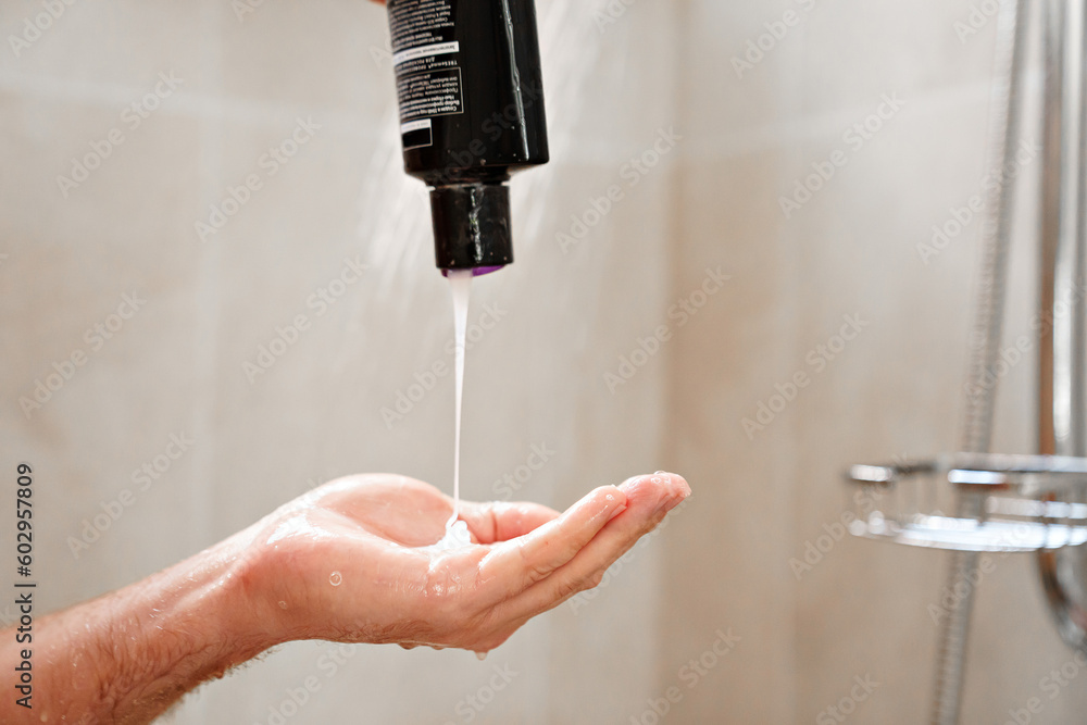 Shampoo is poured from the bottle into the palm of the hand. cosmetics ...