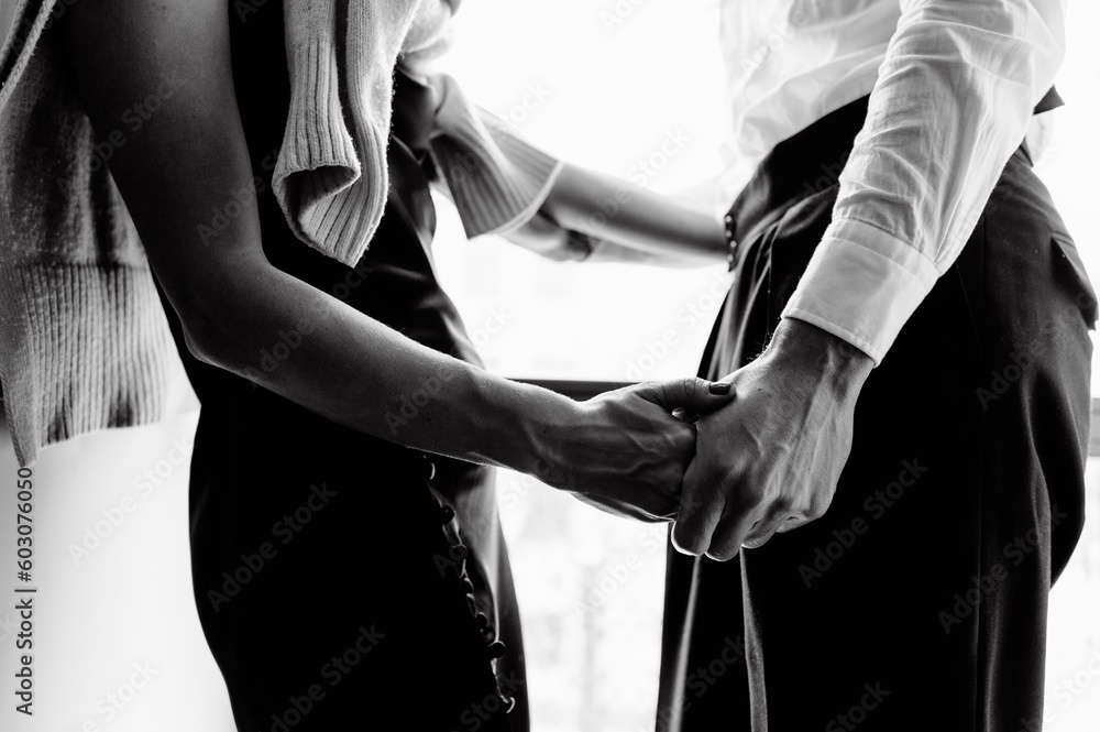 Crop couple holding hands together in room Stock Photo | Adobe Stock