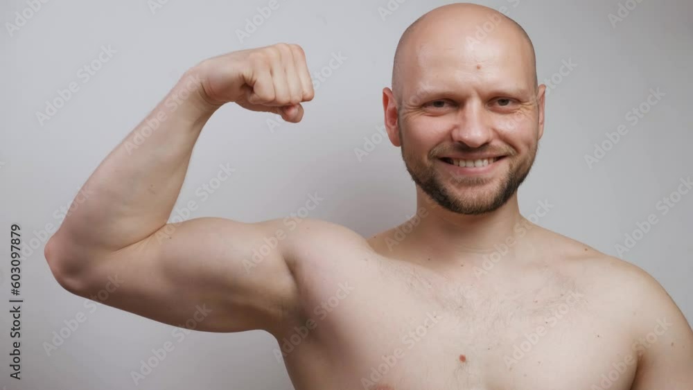 A muscular bald male athlete bodybuilder with a beard and a bare torso ...