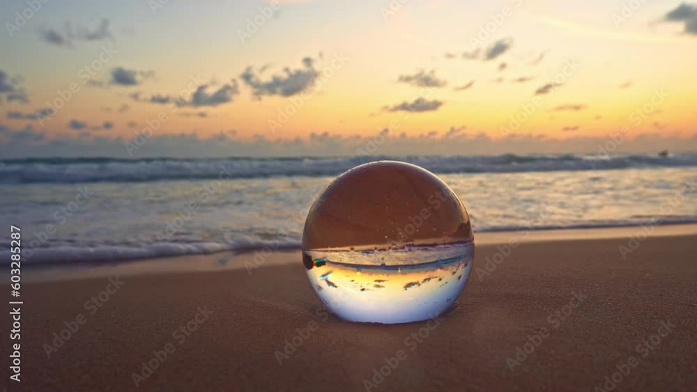 glass ball is placed on the sand at an angle tilted to the horizon..The ...