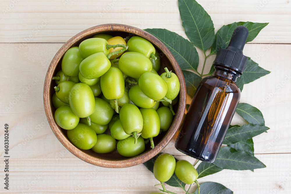 Neem green leaf and neem fruit on wooden table. Neem oil is ...