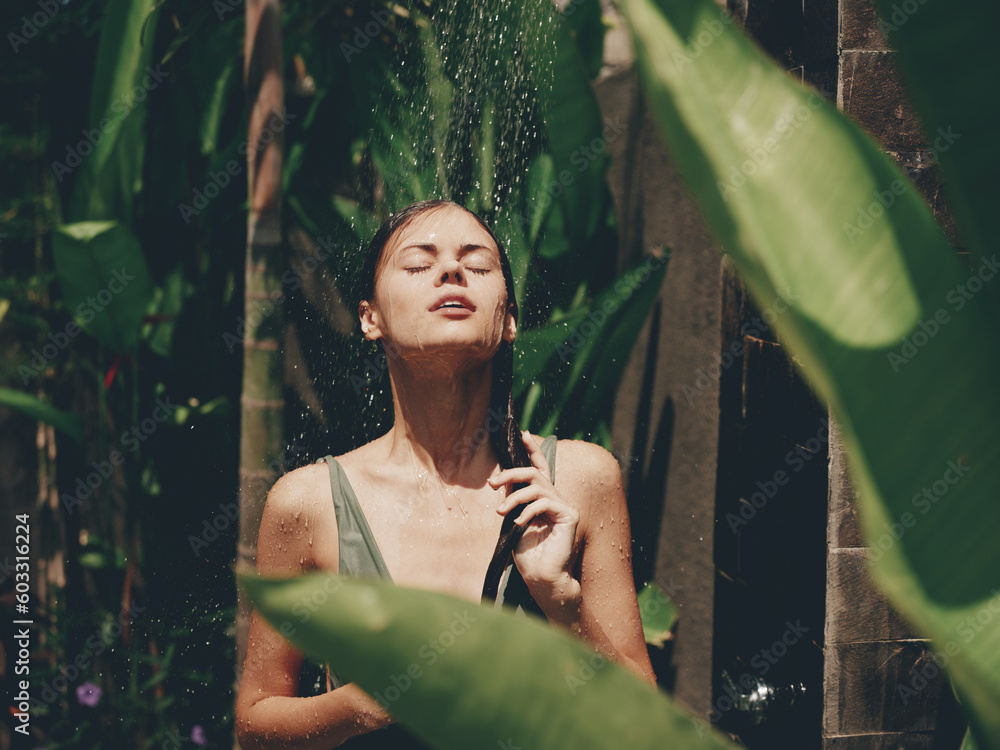 Sexy Woman Body In A Swimsuit Takes A Tropical Shower Outdoors Against