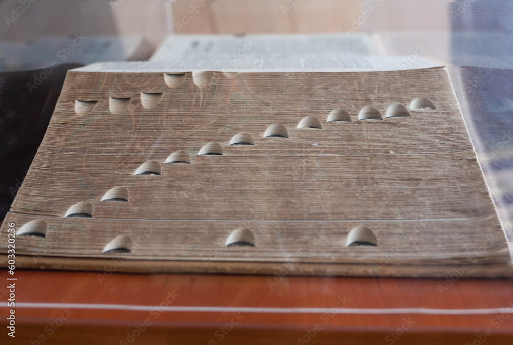 Side view of an old thick dictionary, with recesses, hollow on the side ...