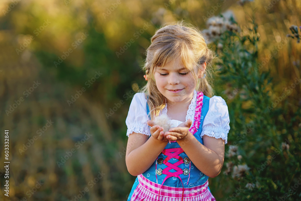 Cute little kid girl in traditional Bavarian costume in wheat field ...