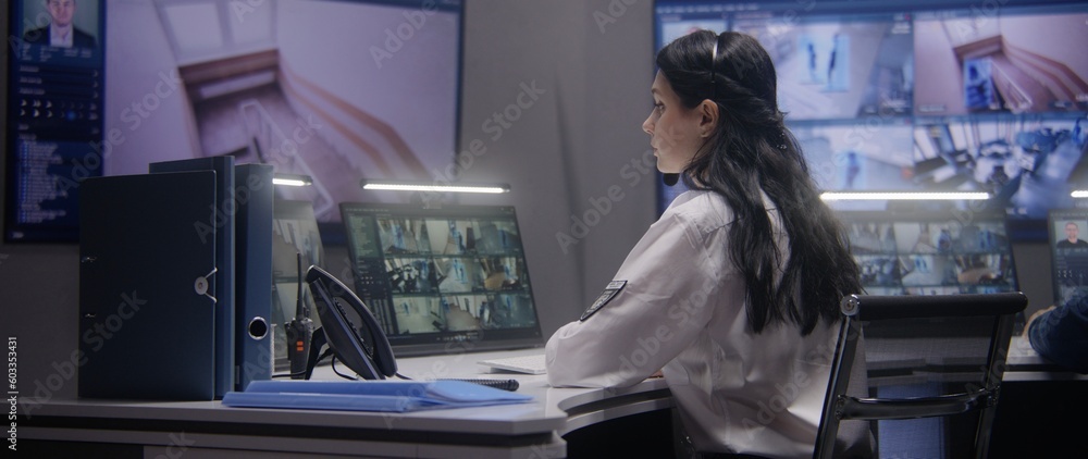 Female security officer works on computer in police monitoring center ...
