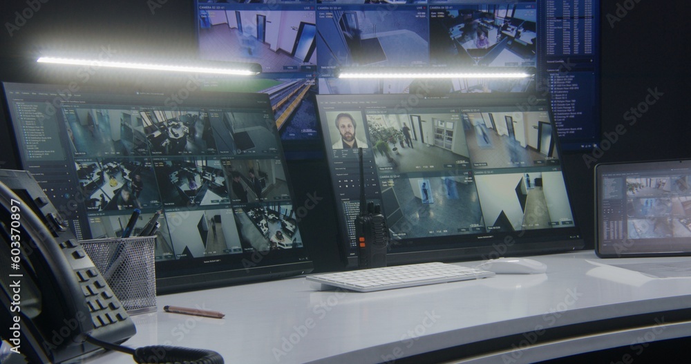 Computer monitors and tablet showing video footage of surveillance ...